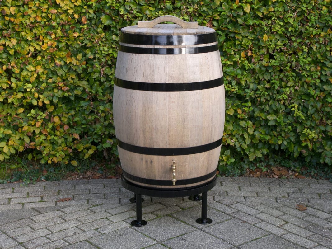 Regenton met zwarte banden en messing kraan zwarte ijzeren verhoger ...